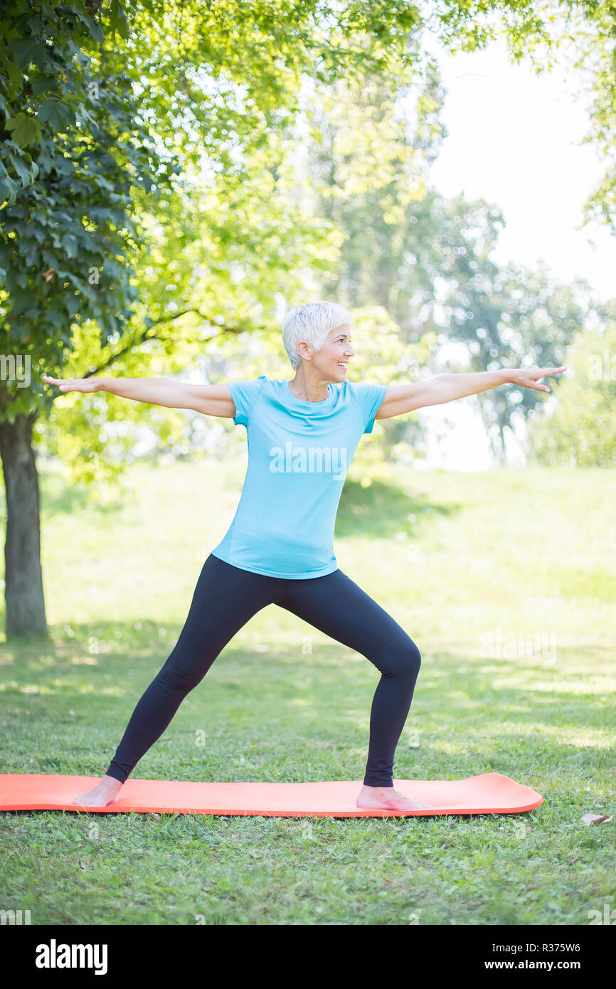 Senior ladies enhancing body flexibility by stretching in the park ...