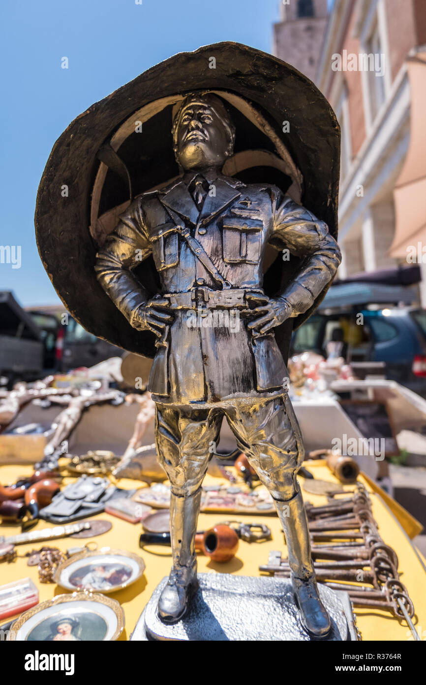 Funny image of a helmet on a little Mussolini steel statue on a table ...