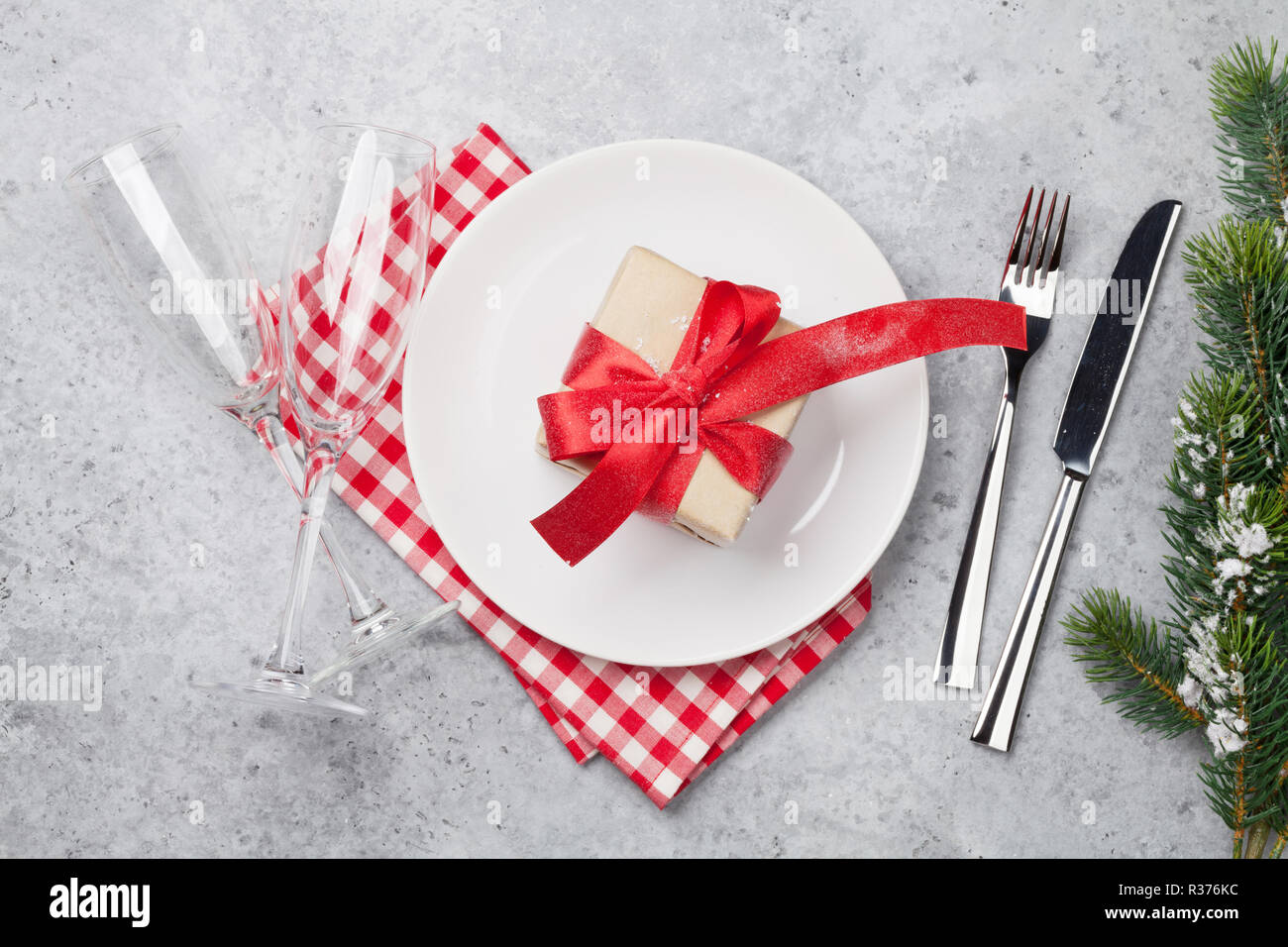 Christmas table setting with champagne, gift box and fir tree branch ...