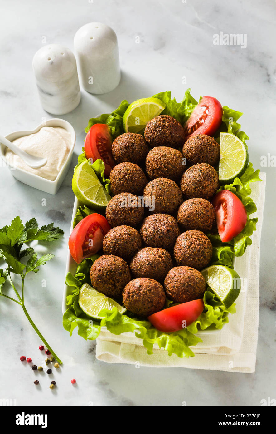 vegan falafel with cashew cheese sauce on a table with chopped tomatoes ...