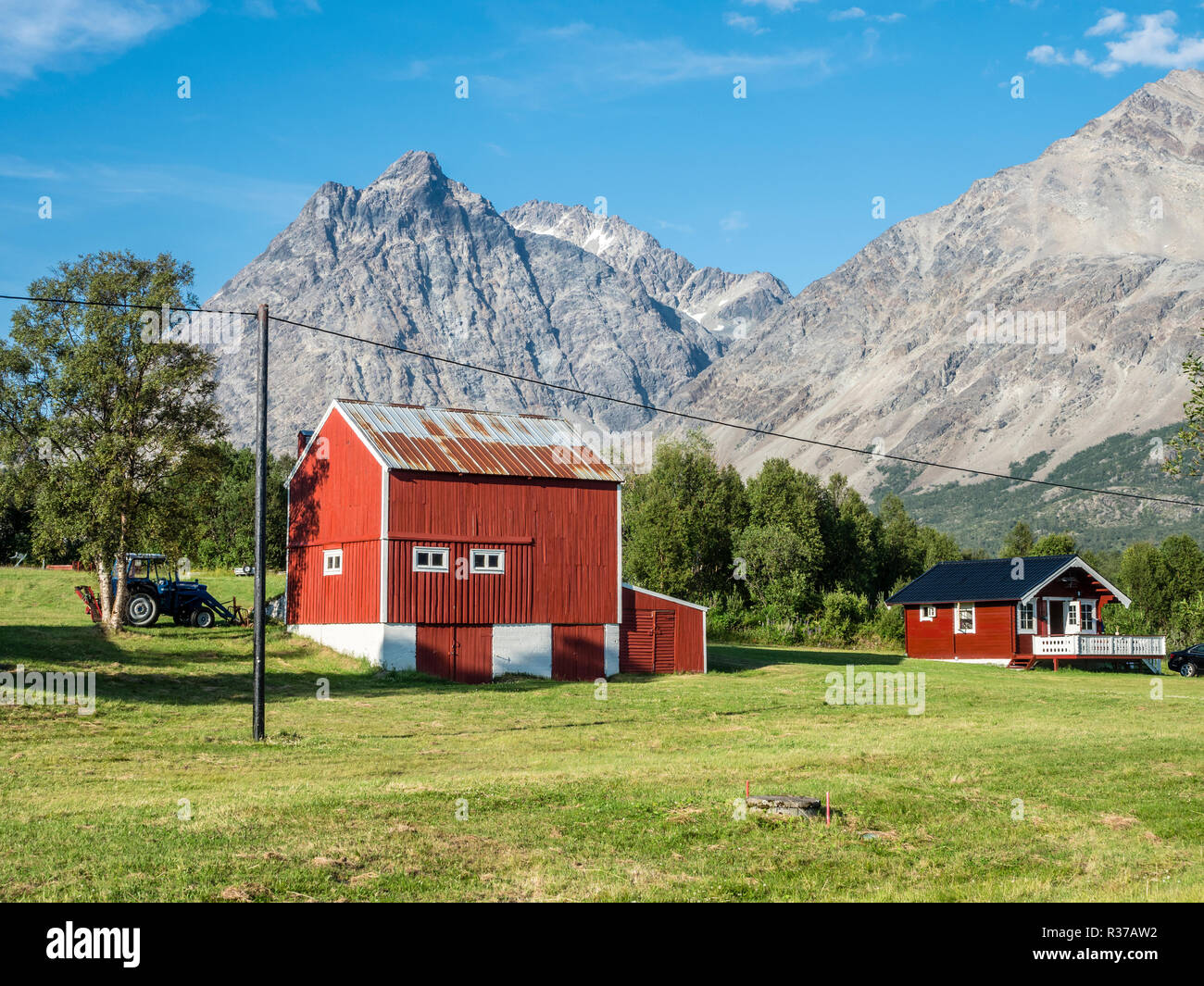 Red wooden barn and cottage south of Svensby at the Kjosenfjord, steep ...