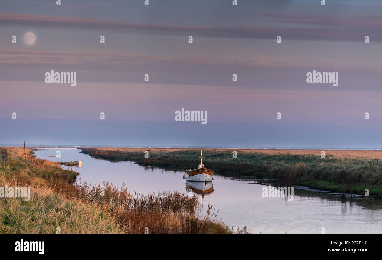 The full Moon rising over Saltfleet Haven, Lincolnshire during a winter ...