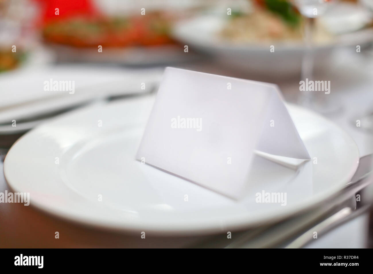 Empty classic white plate in a restaurant with a blank card and ...