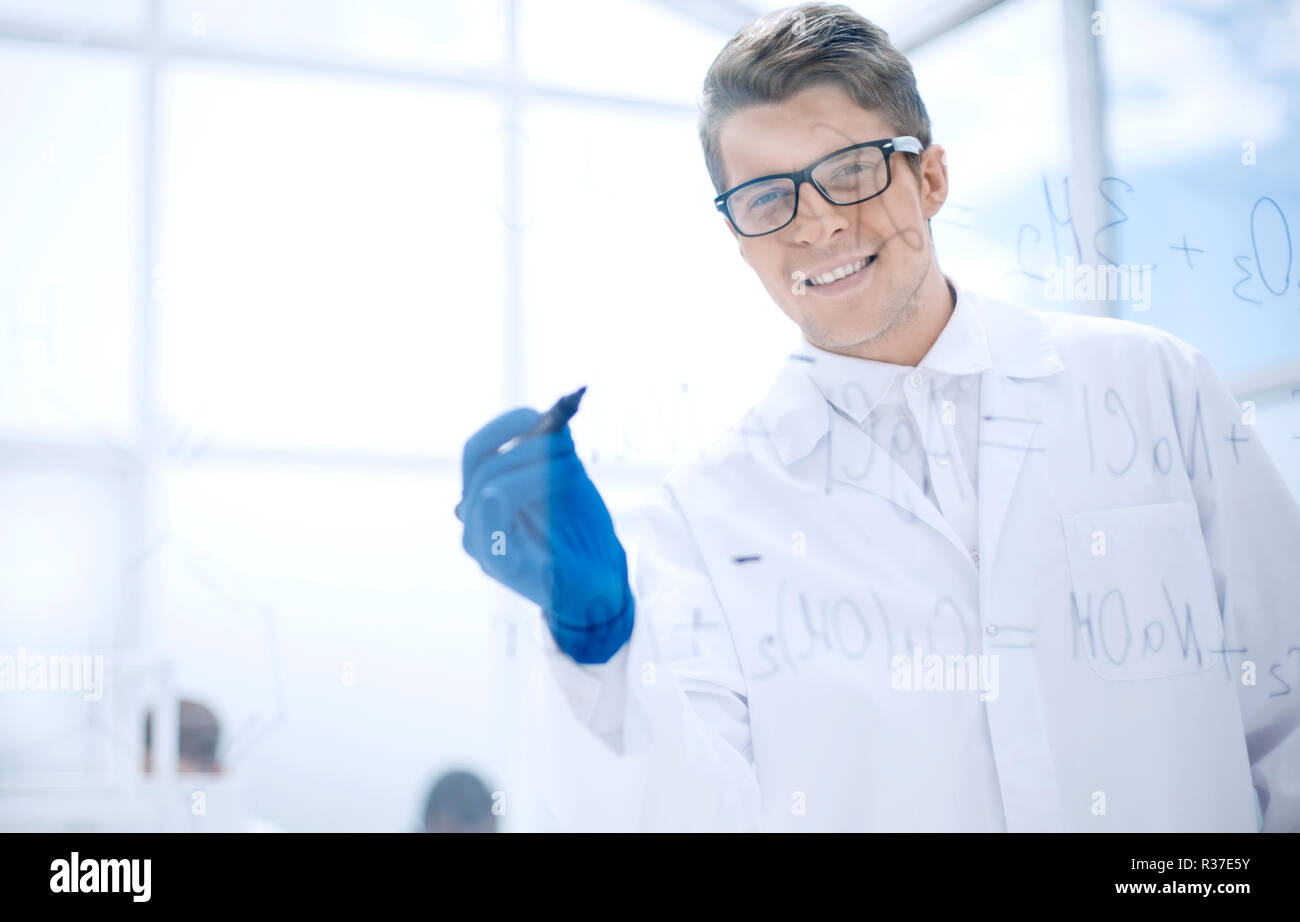 successful scientist writes a formula on a glass Board Stock Photo - Alamy