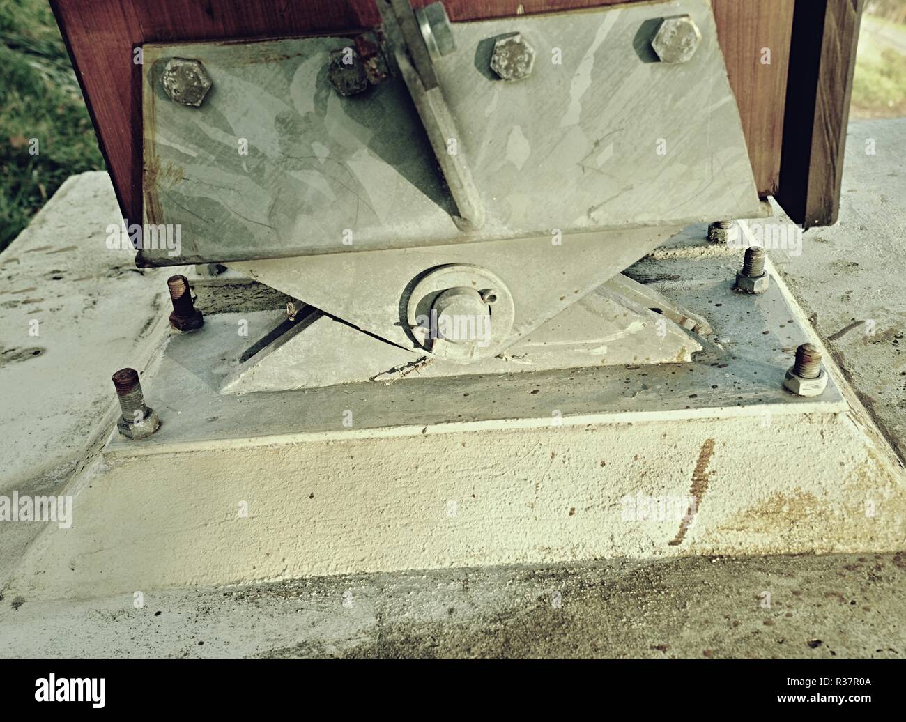 Steel tie joint with swing beam and anchored into concrete. Modern foot ...