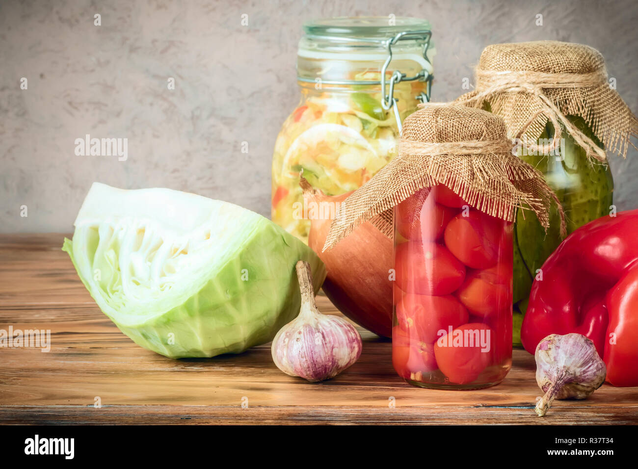 Set of fermented vegetables in jars on wooden rustic table. Cabbage ...