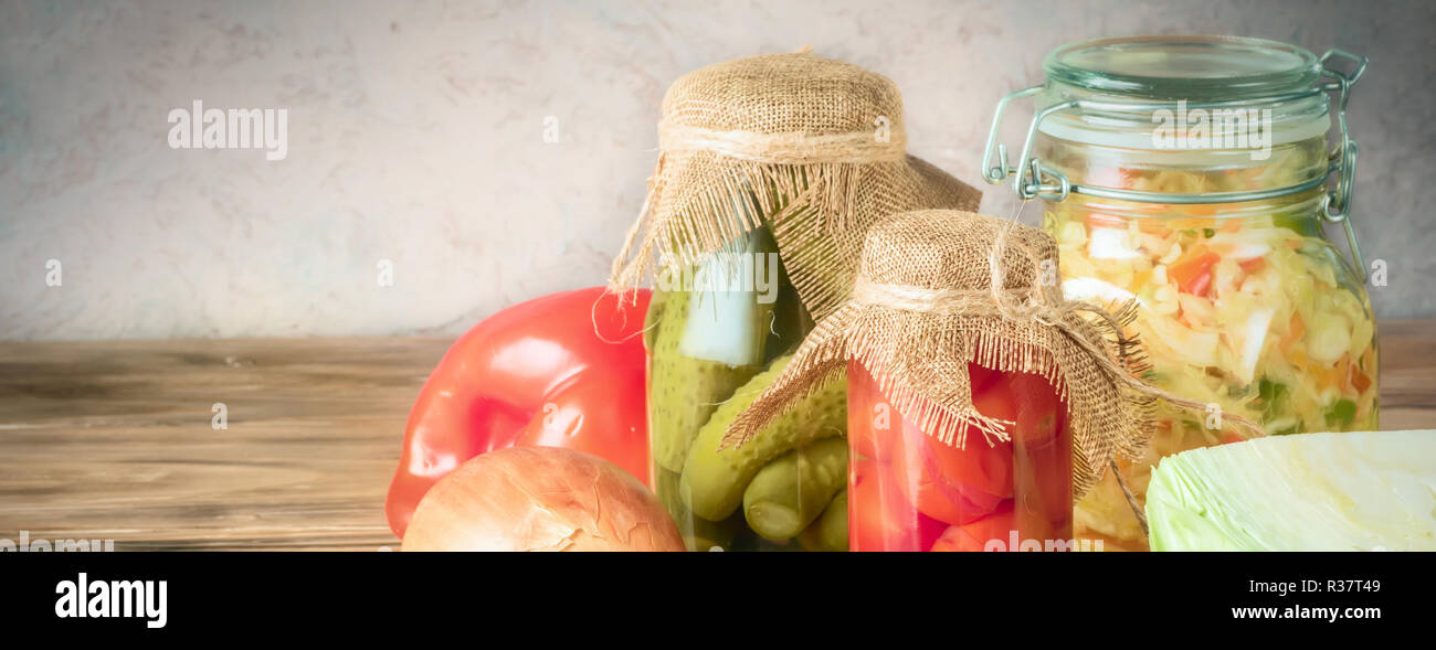 Set of fermented vegetables in jars on wooden rustic table. Cabbage ...