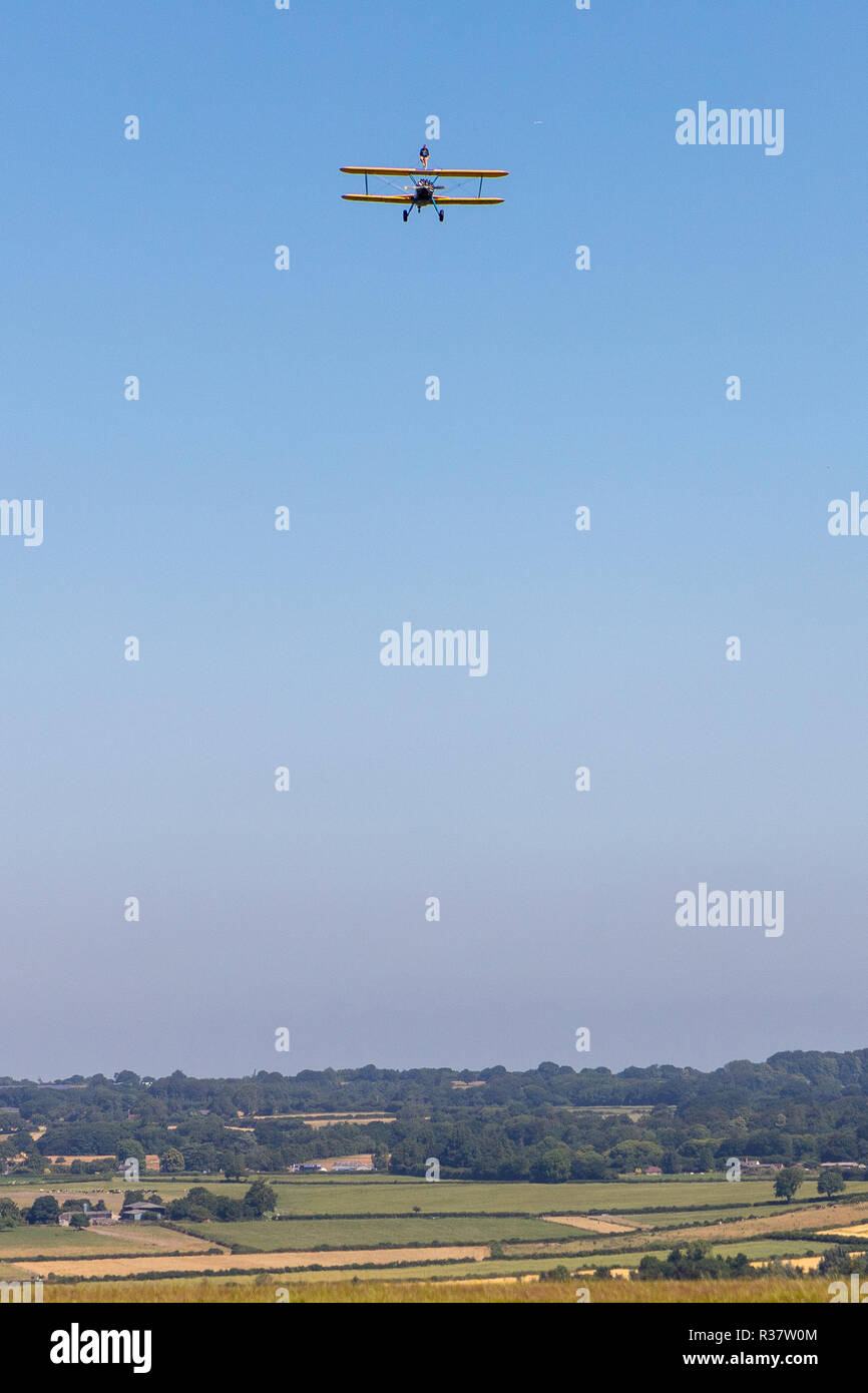 Wing walking on plane over English countryside Stock Photo - Alamy