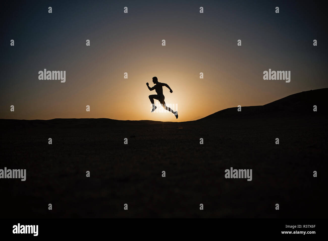 runner. silhouette of running man on sunset fiery sky background in ...