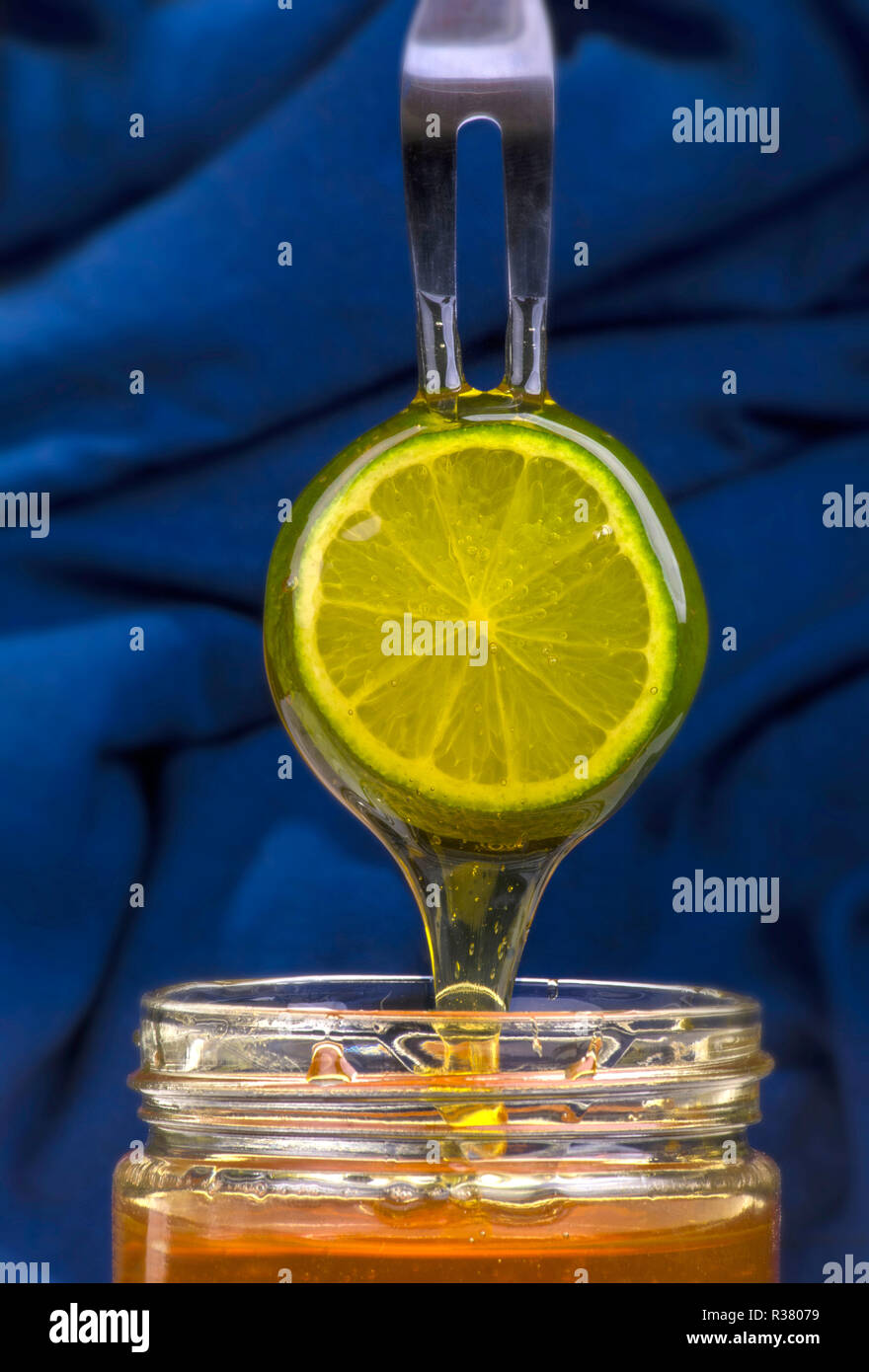 honey flowing over a slice of lemon Stock Photo - Alamy