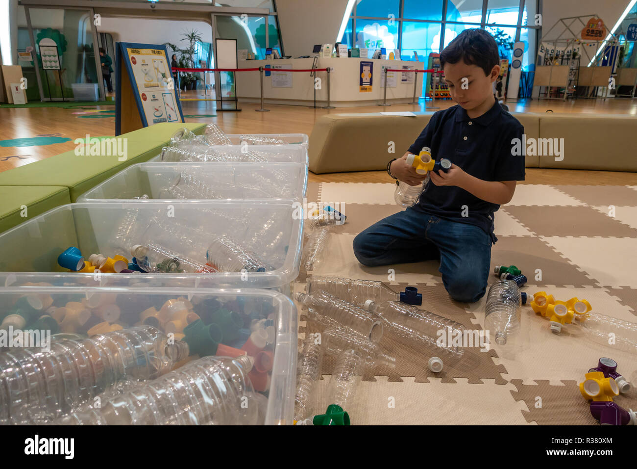 A child plays with a plastic bottle based constuction set at a children ...