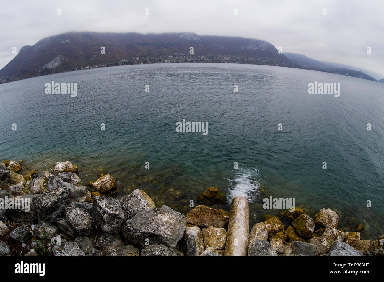Pipe rejecting fluids in mountain lake, Annecy, Haute-Savoie, France ...