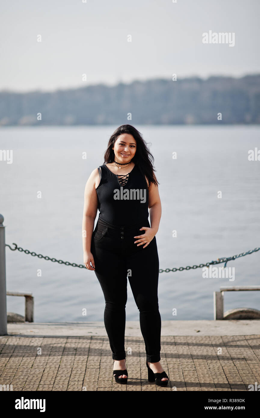 Pretty latino model girl from Ecuador wear on black posed against lake ...