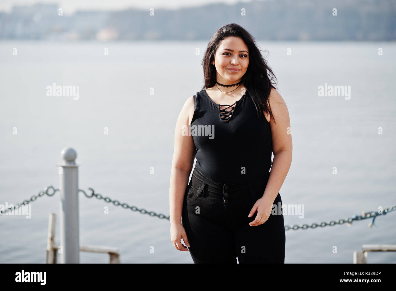 Pretty latino model girl from Ecuador wear on black posed against lake ...