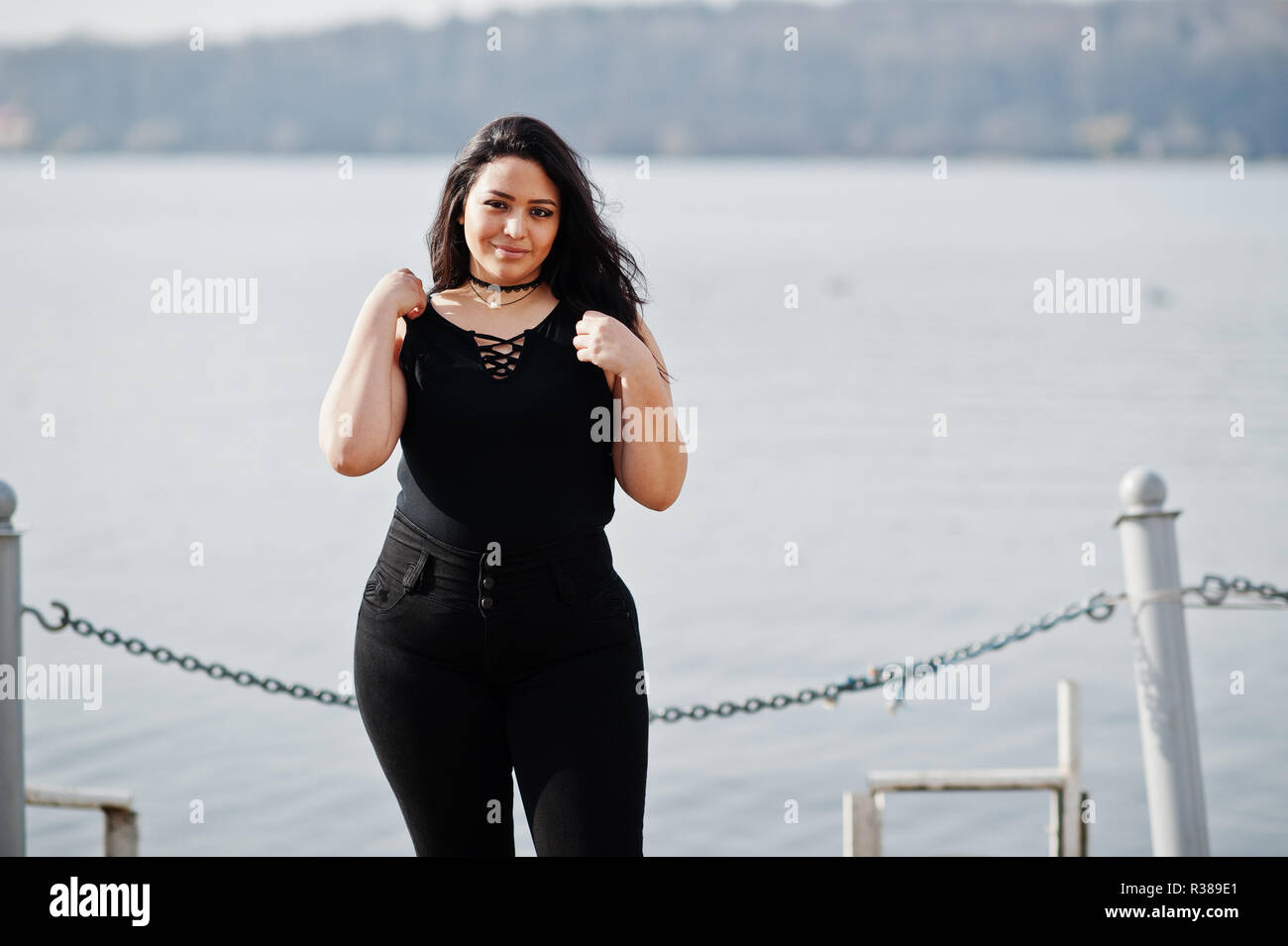 Pretty latino model girl from Ecuador wear on black posed against lake ...