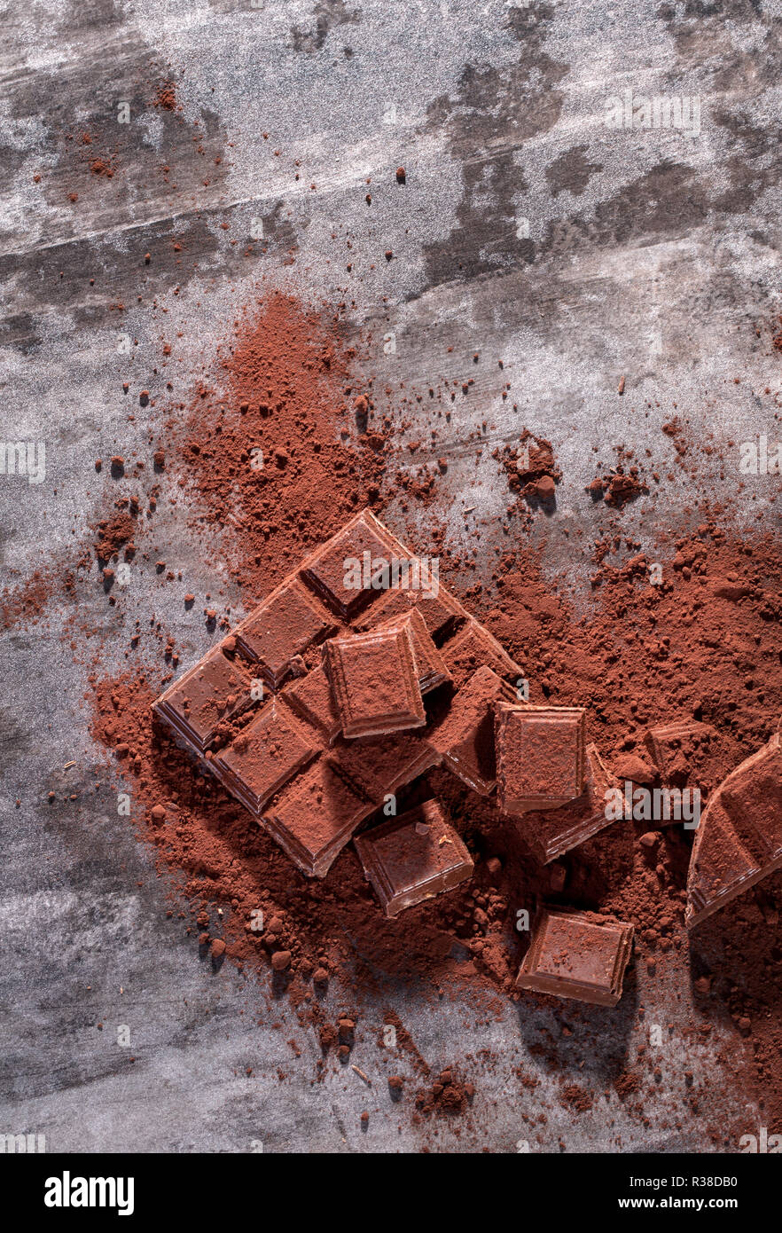 Broken chocolate pieces and cocoa powder on wooden background Stock ...