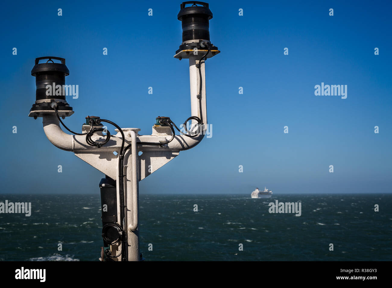 Close up of navigation mast on ferry at sea with another ferry in ...