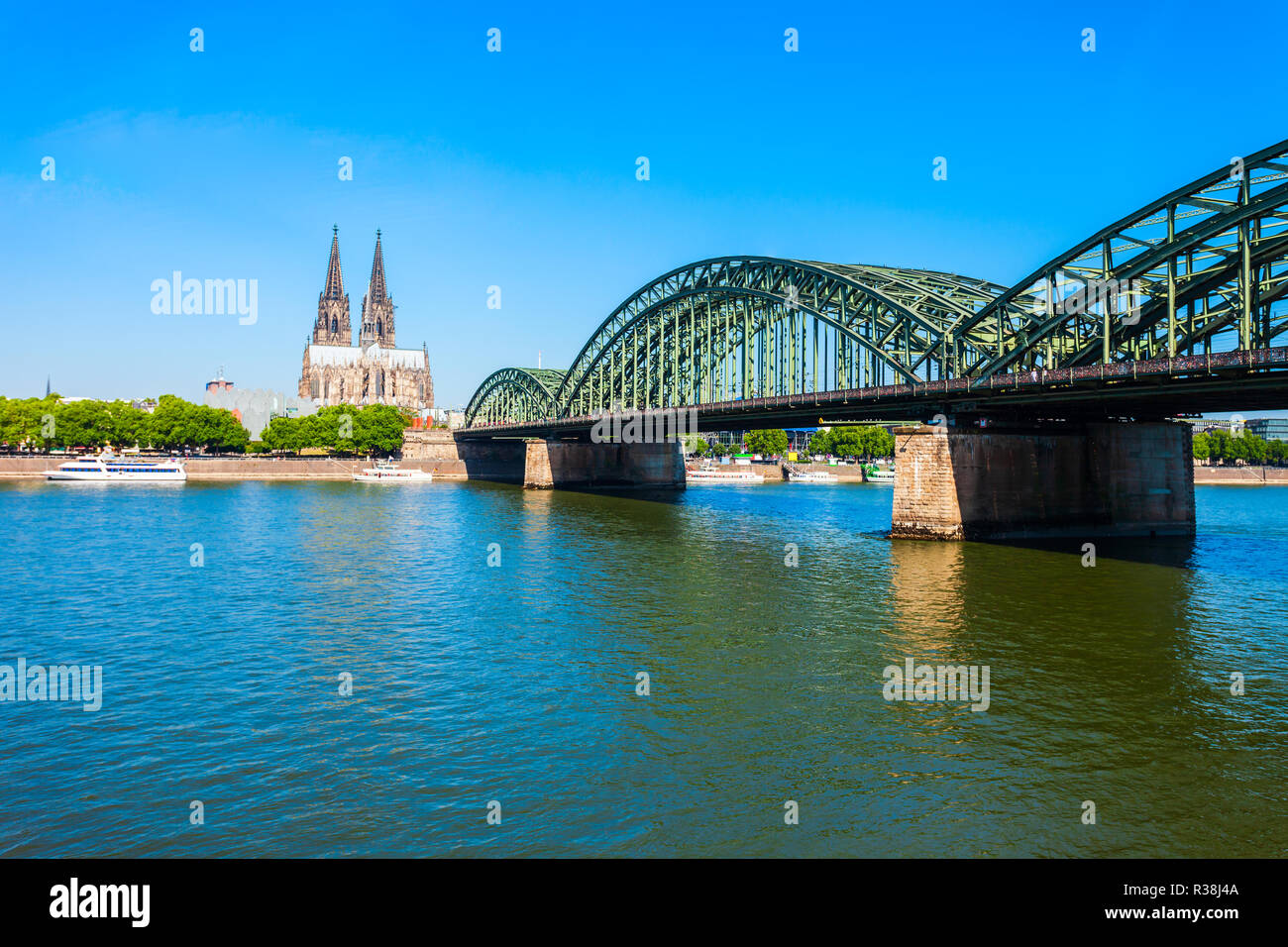 Cologne Cathedral and Hohenzollern Bridge through Rhine river in ...