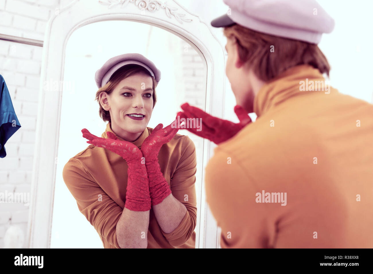 Short-haired queer young man posing against full length mirror Stock ...