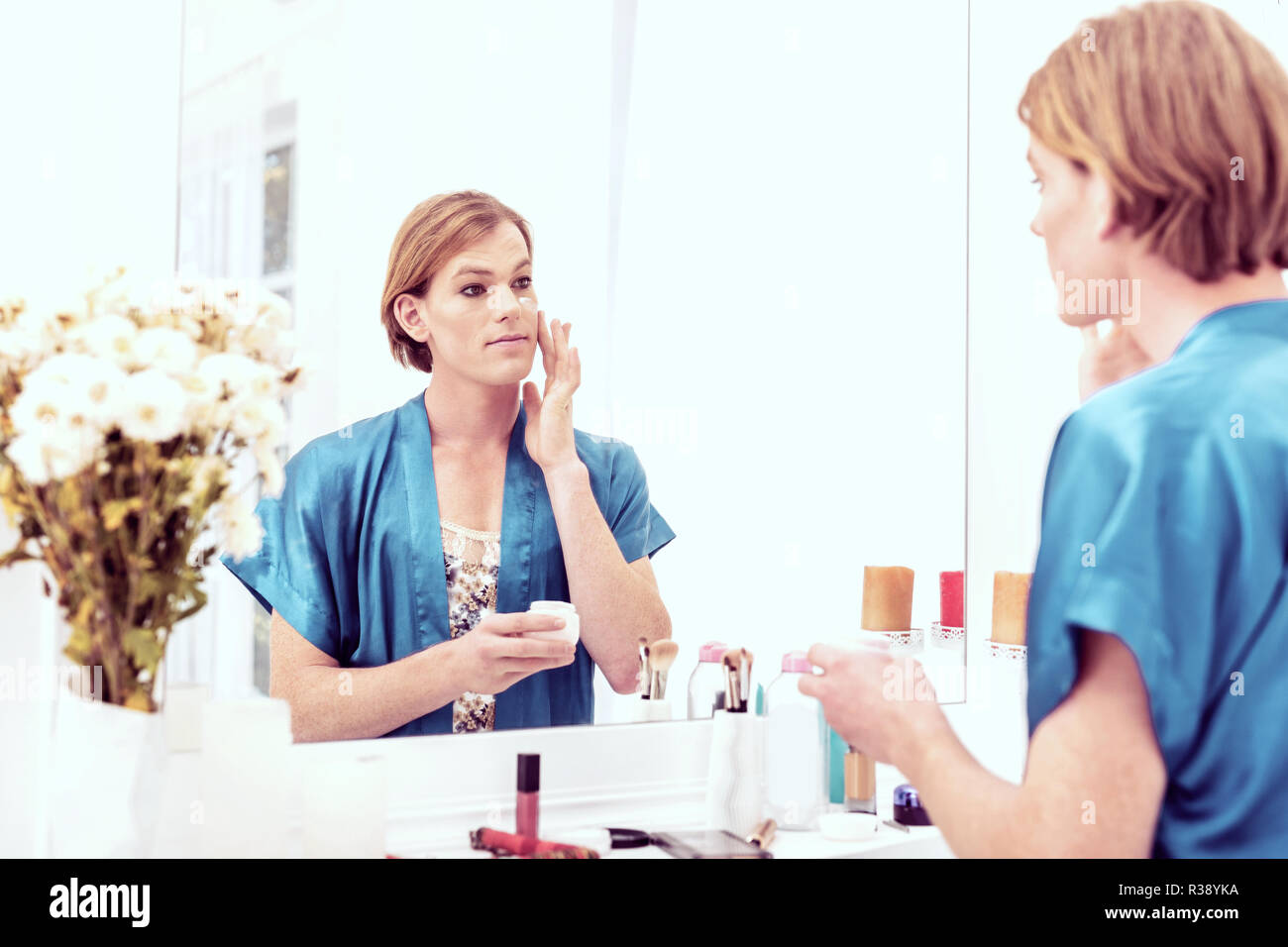 Good-looking young transgender staying against the mirror Stock Photo ...