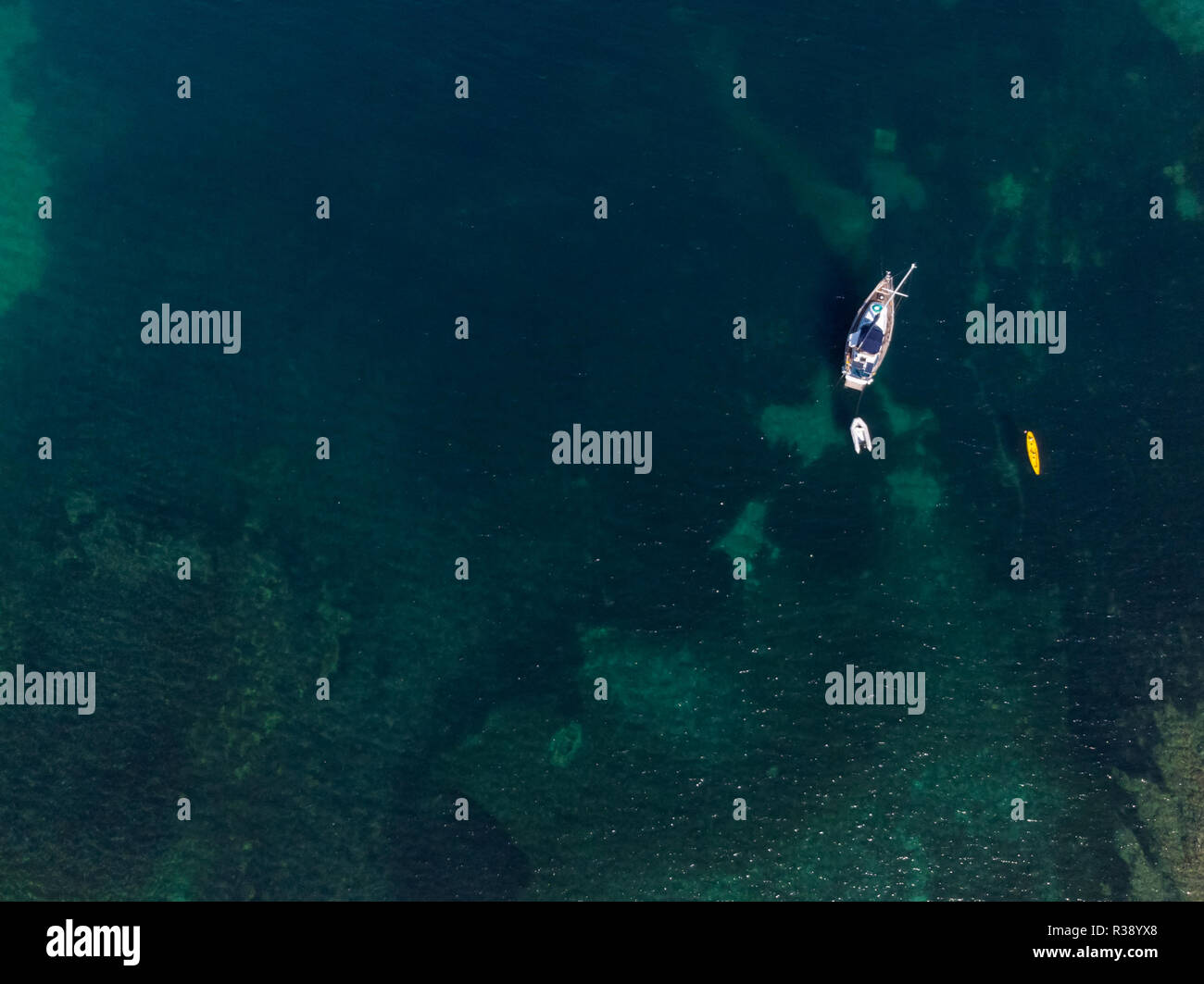 White sailing ship yacht at sea in shallow water near shore. Aerial ...