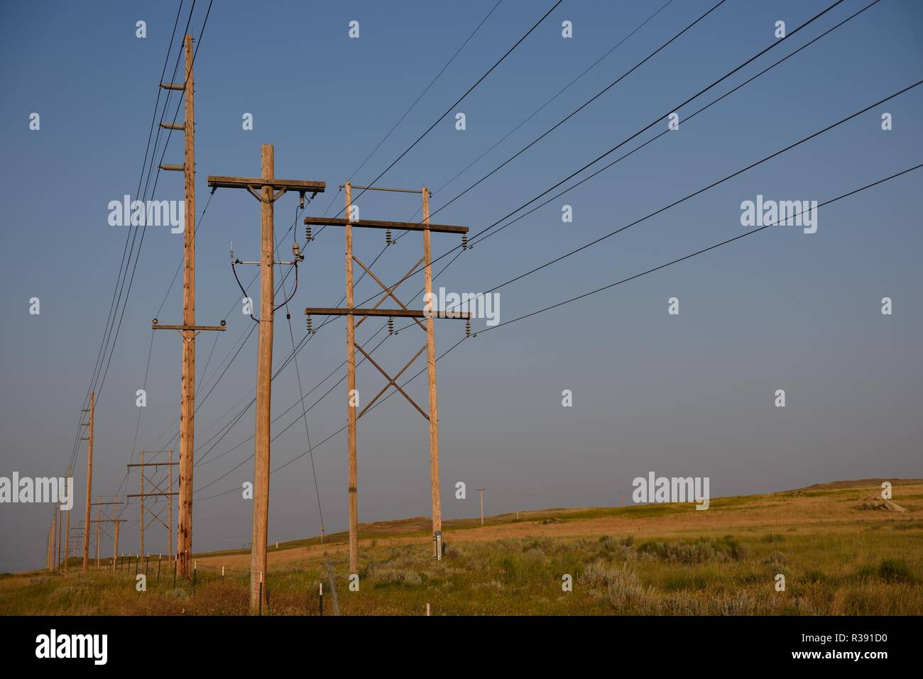Rows of electrical transmission pylons and overhead high voltage power ...
