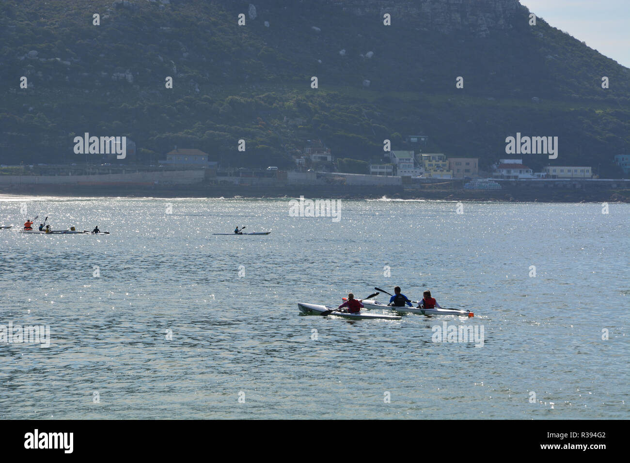 Canoeists paddling along the coast of the False Bay at Fish Hoek ...