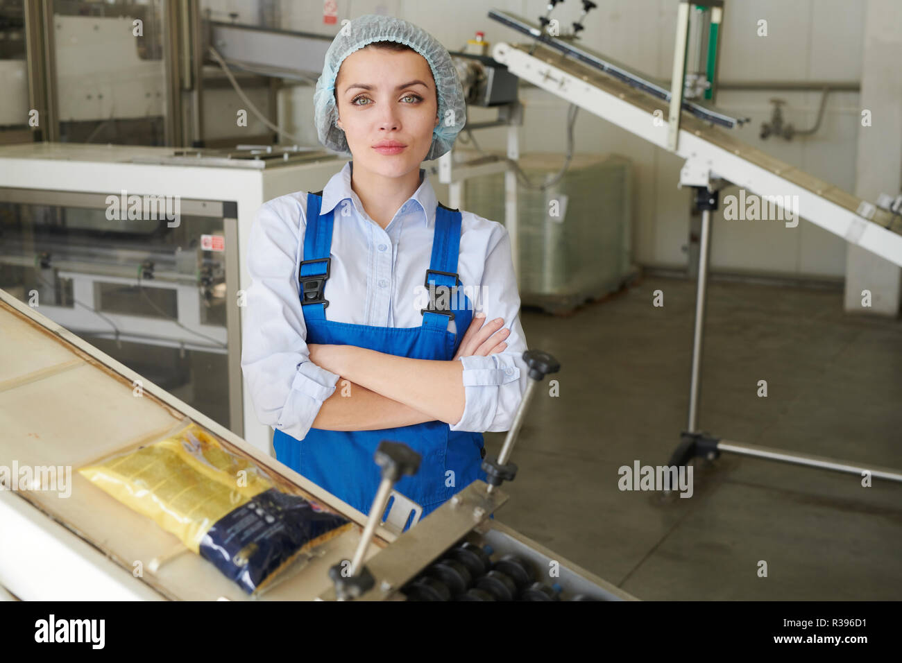 Female Worker Posing by Packaging Line Stock Photo - Alamy