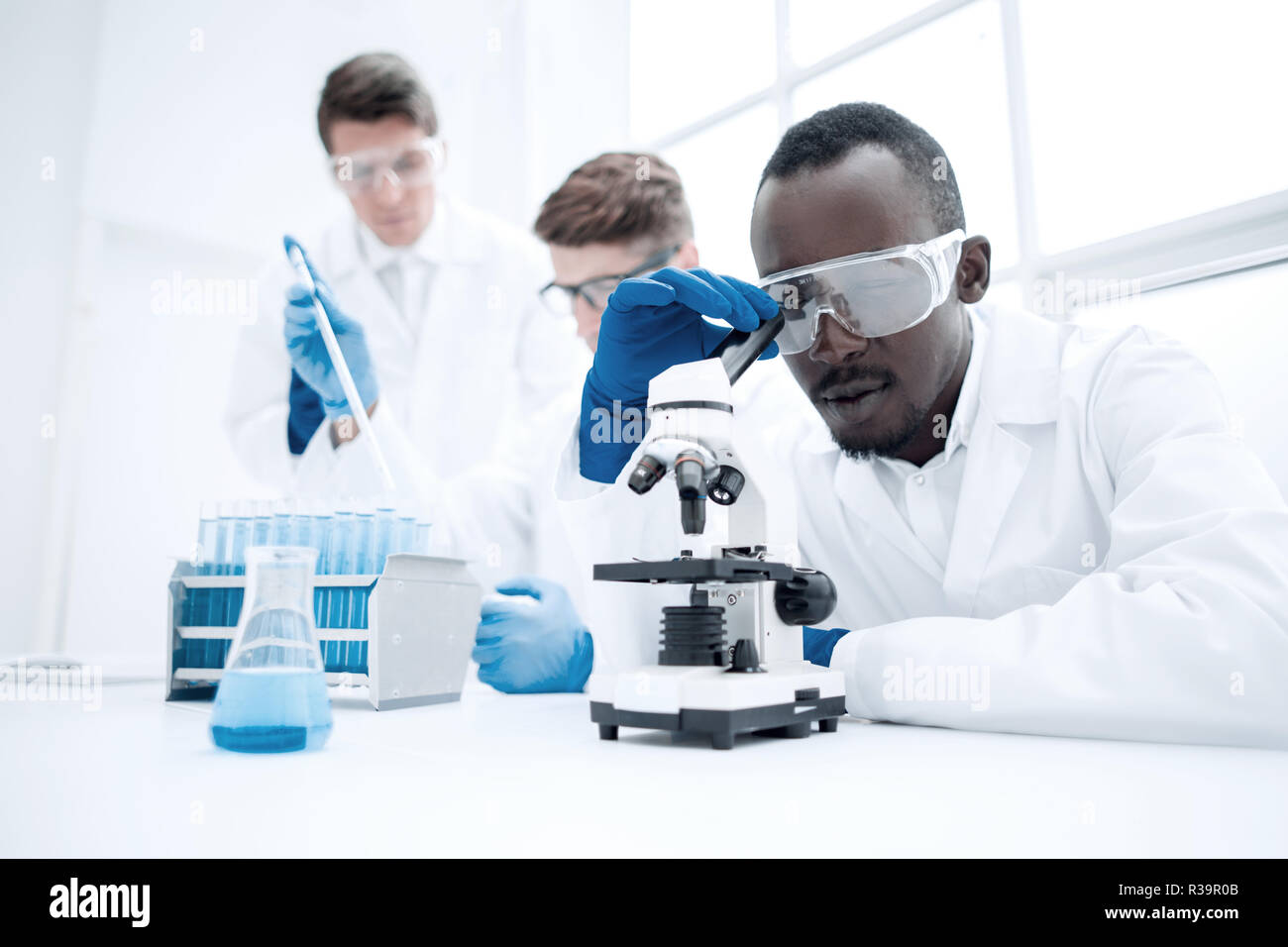 modern scientist looking through a microscope Stock Photo - Alamy