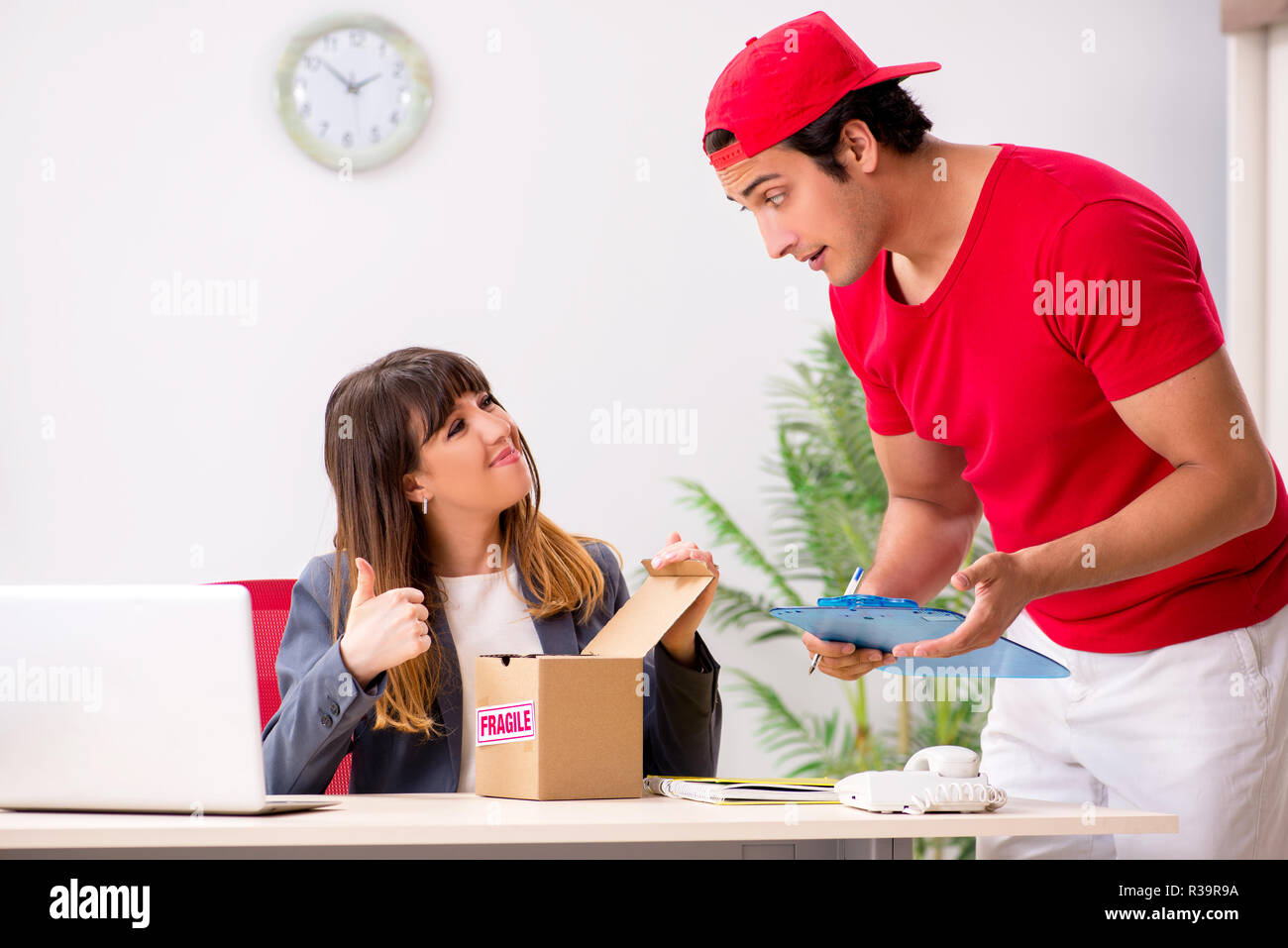 Courier delivering parcel to the office Stock Photo - Alamy