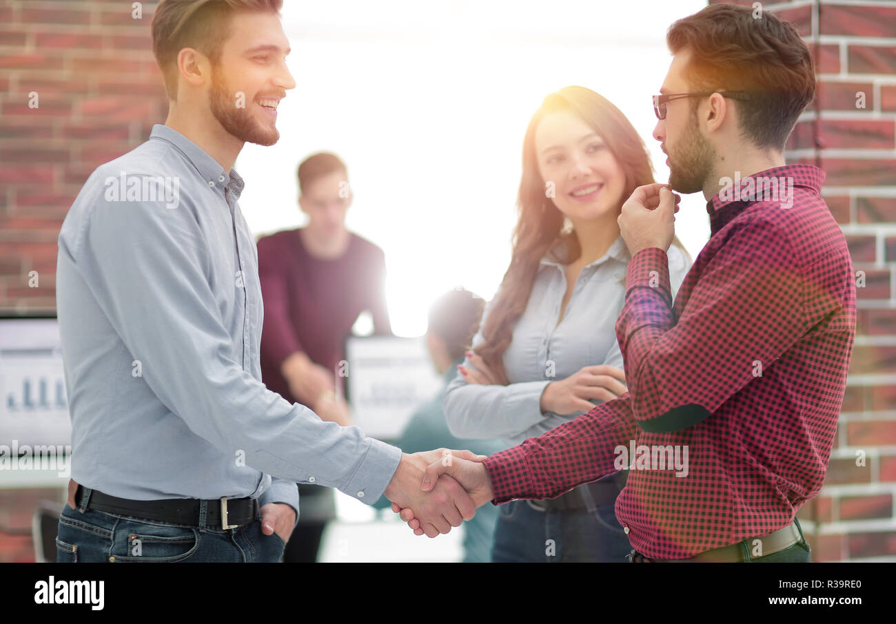 Smiling businessman shaking hands with colleague in office Stock Photo ...