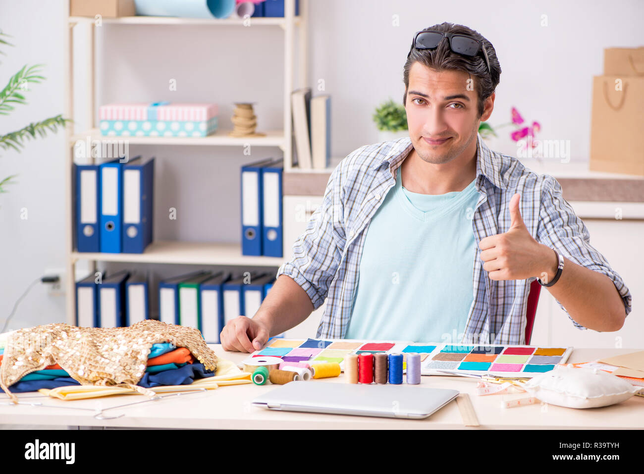 Young handsome tailor working in his workshop Stock Photo - Alamy