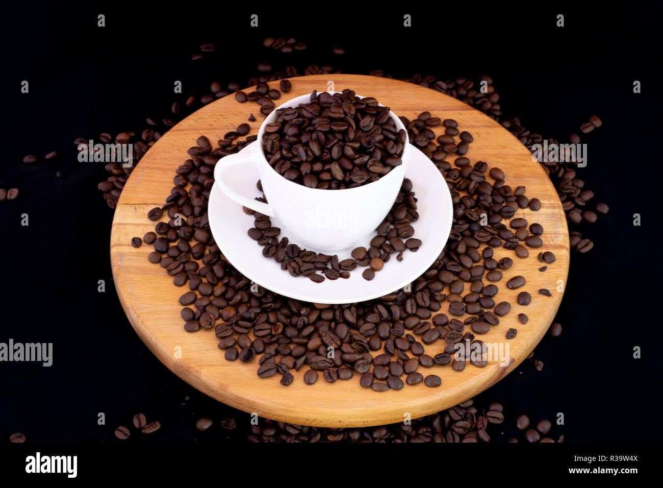 Coffee beans inside the coffee mug on wood with isolated black ...