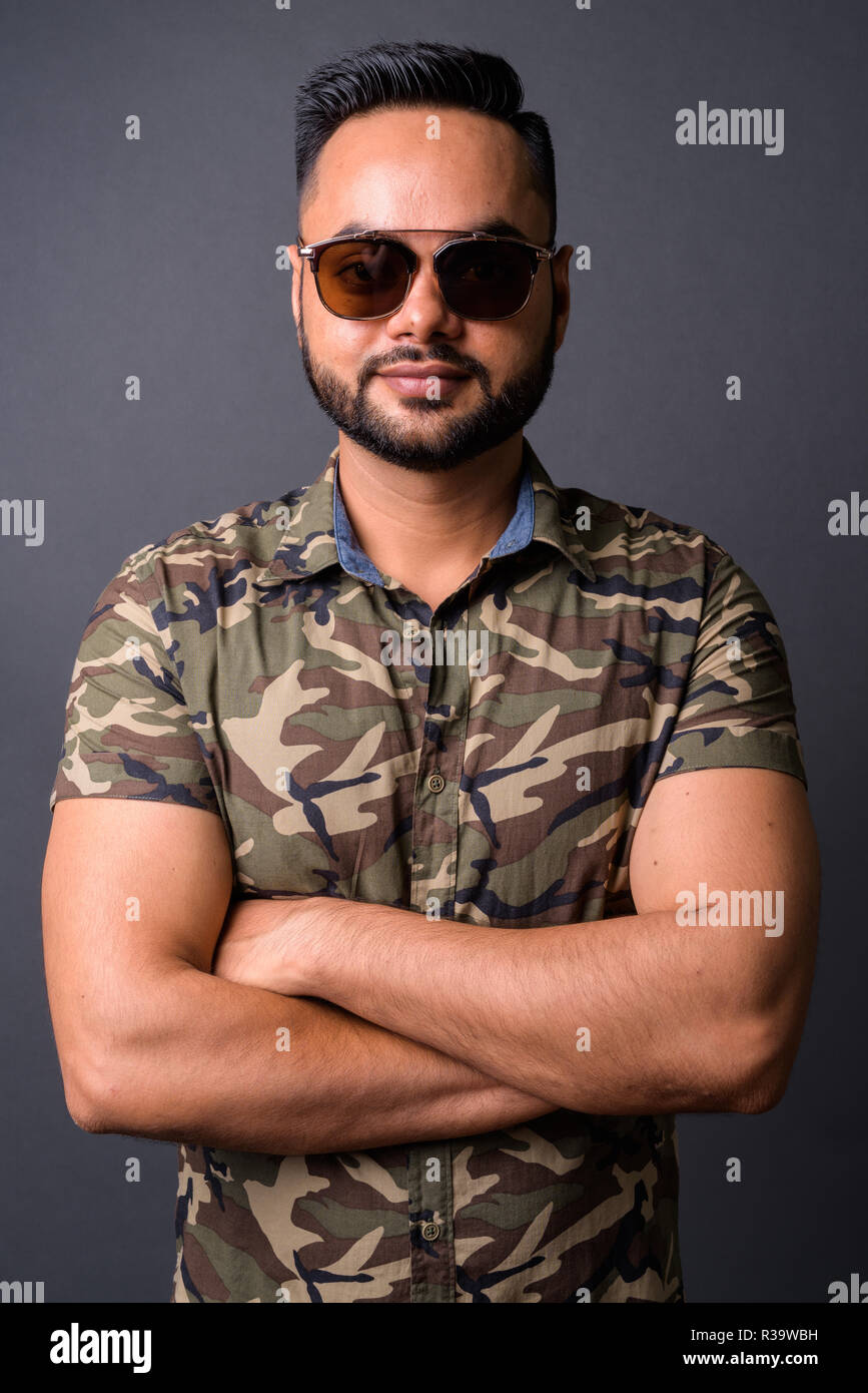 Young bearded Indian man against gray background Stock Photo - Alamy