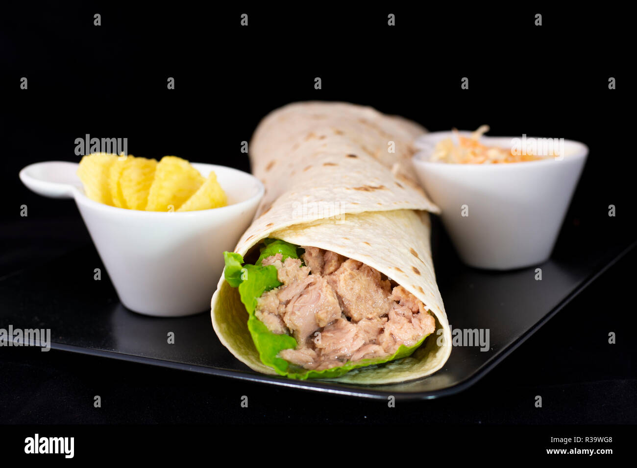 Delicious tuna fish wrap with salad inside with isolated black ...