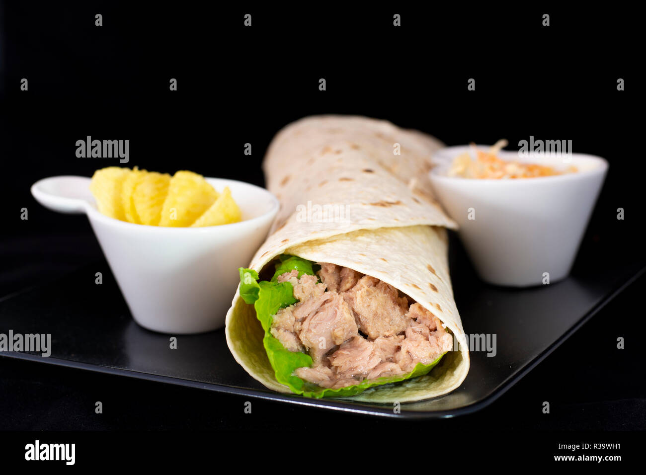 Delicious tuna fish wrap with salad inside with isolated black ...