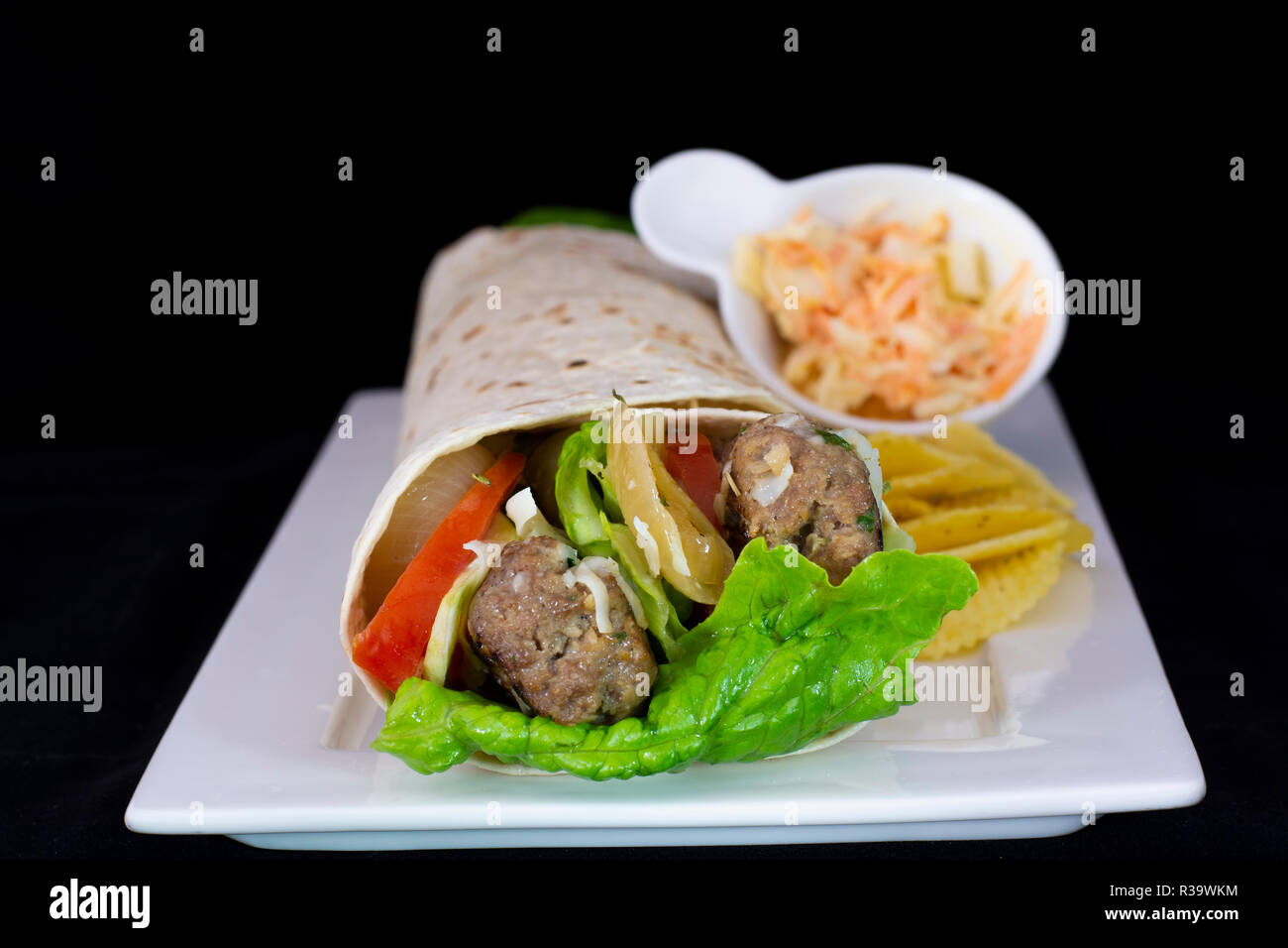Delicious meatball wrap with salad inside with isolated black ...