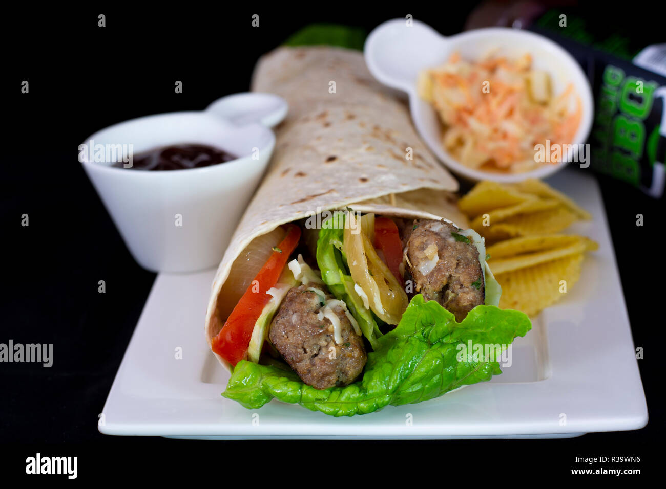 Delicious meatball wrap with salad inside with isolated black ...