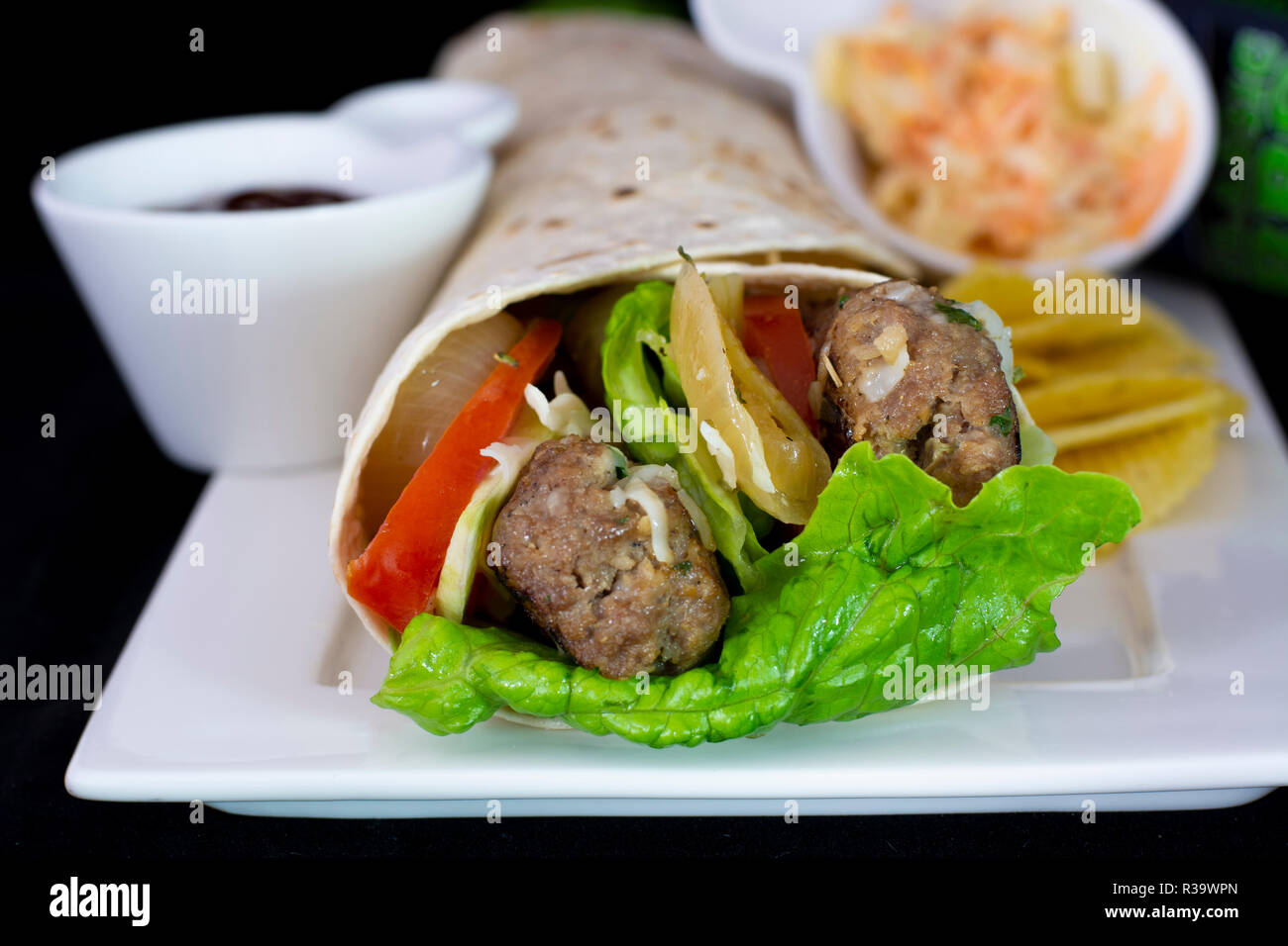 Delicious meatball wrap with salad inside with isolated black ...