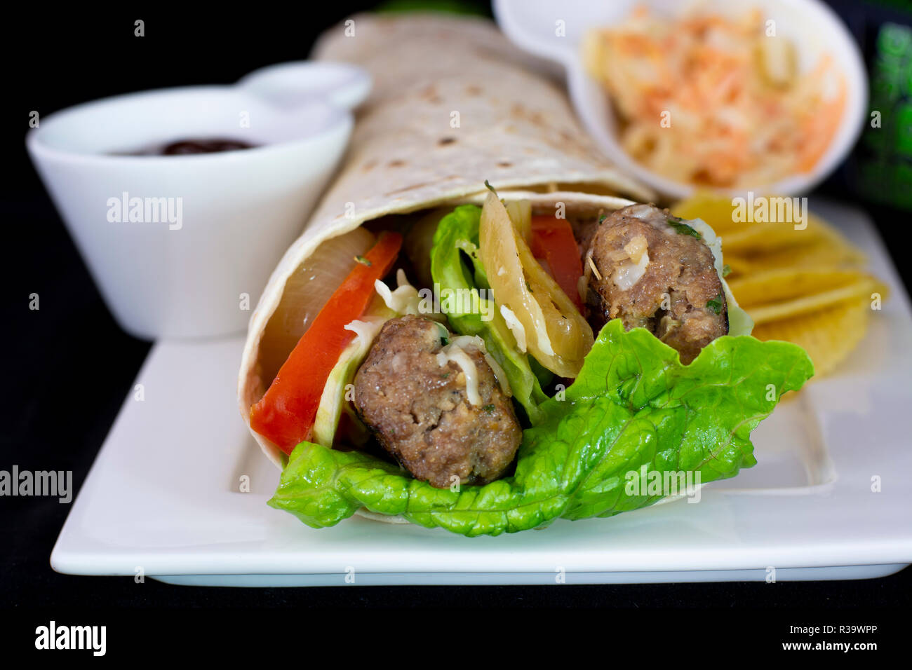 Delicious meatball wrap with salad inside with isolated black ...