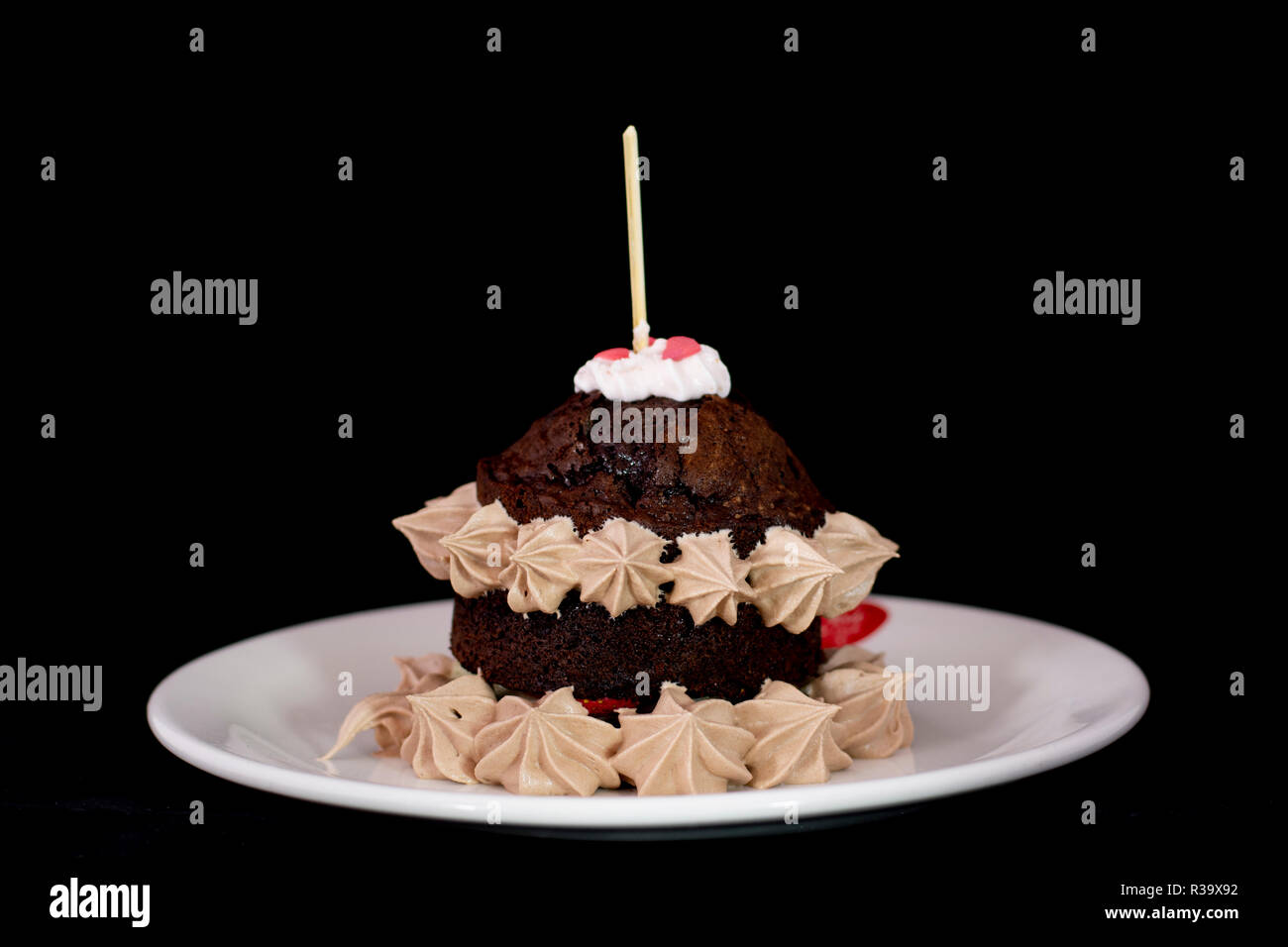 Fresh baked chocolate cake with whipped cream around on white plate ...
