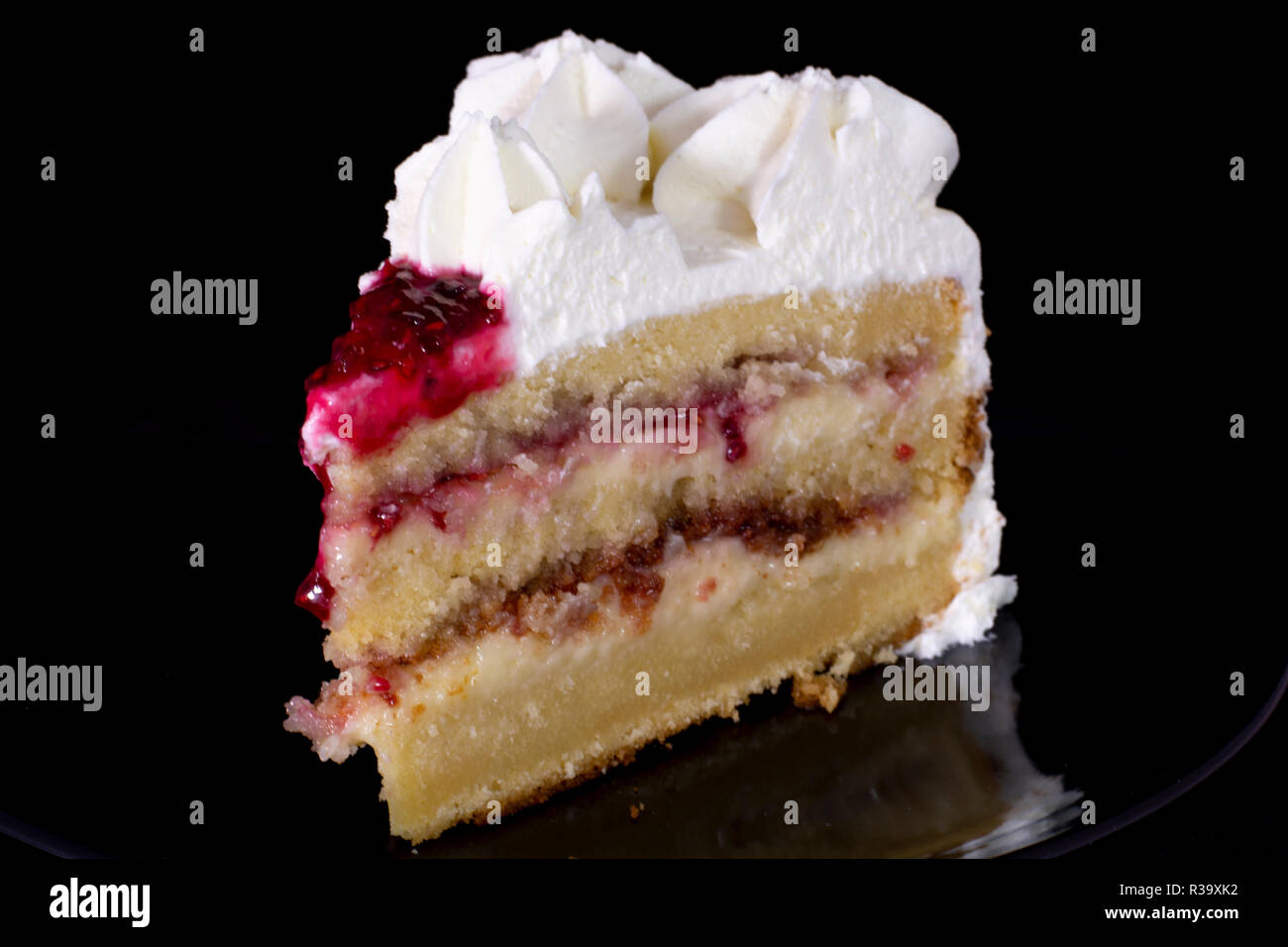 White cream cake with raspberry dressing on it with isolated black ...