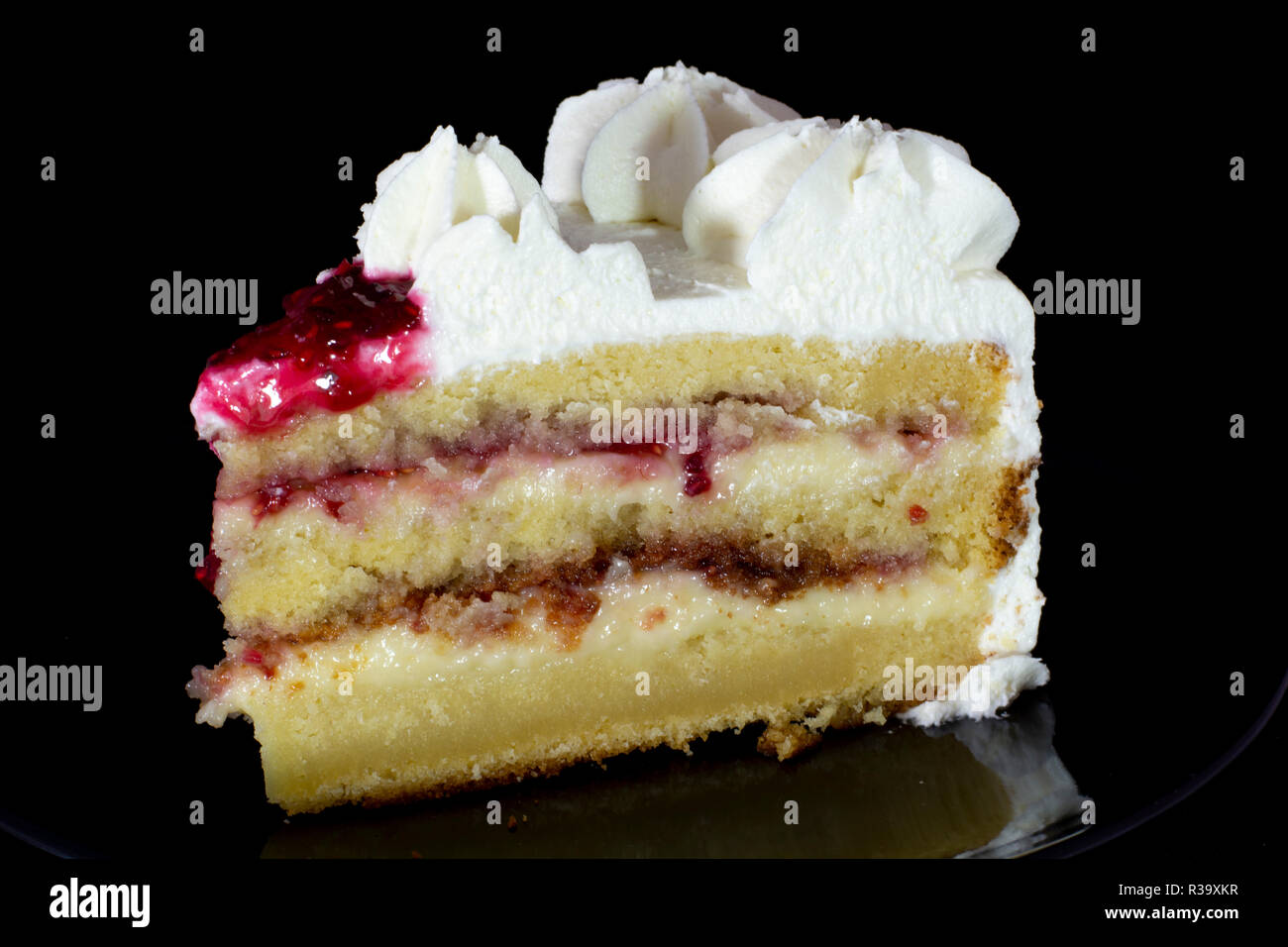 White cream cake with raspberry dressing on it with isolated black ...