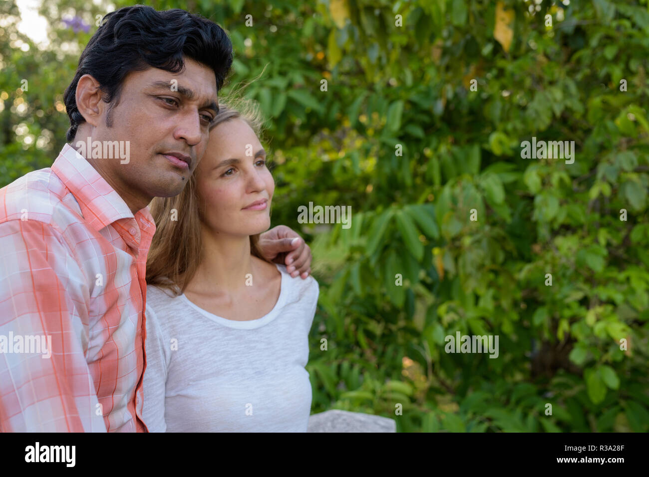 Multi ethnic couple thinking and in love at peaceful green park Stock ...