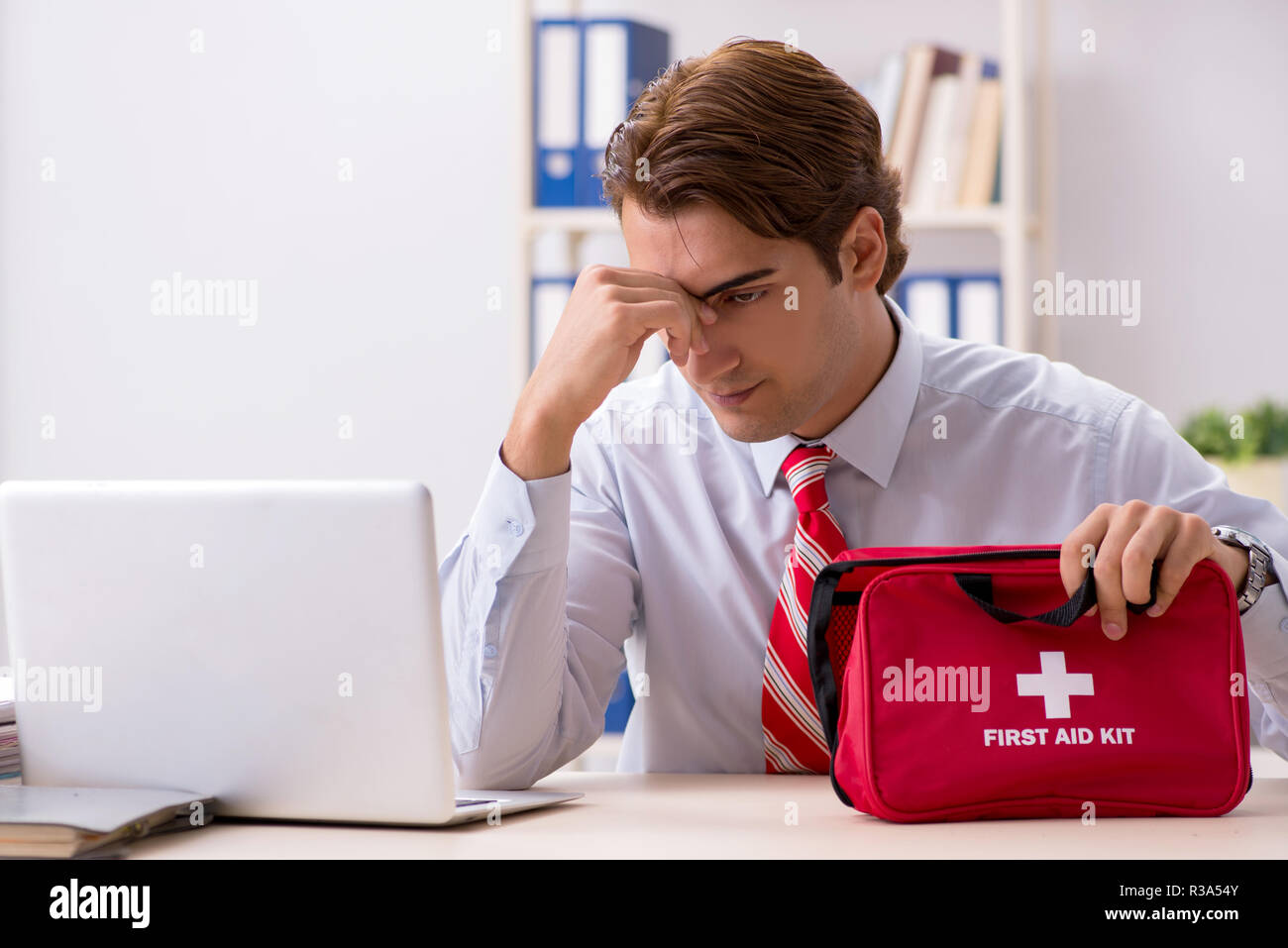 Man with first aid kit in the office Stock Photo - Alamy