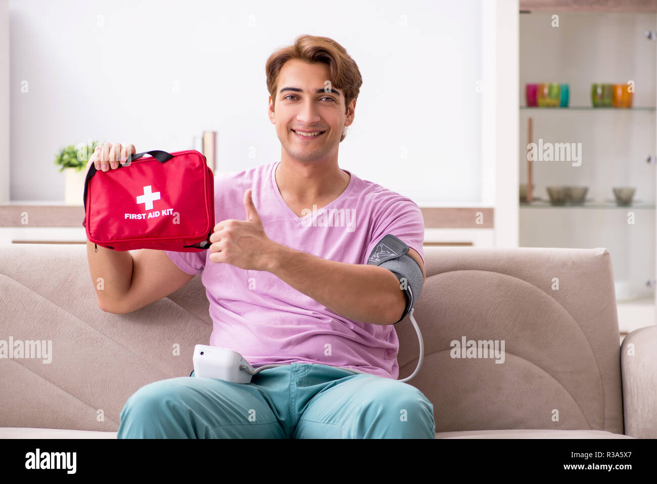 Sick man at home with first aid kit Stock Photo - Alamy