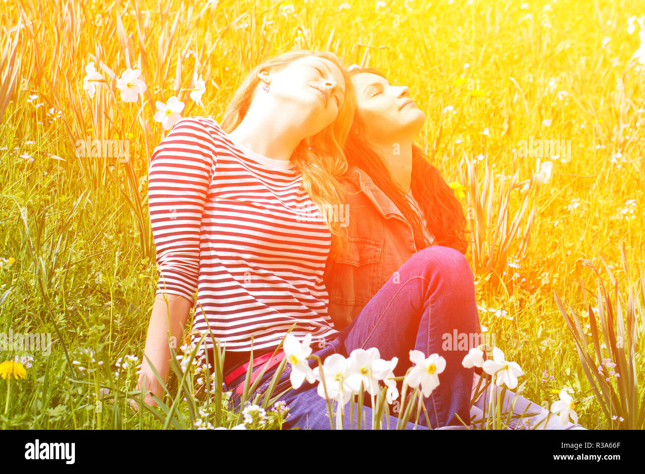 two young women enjoying the spring sunshine Stock Photo - Alamy