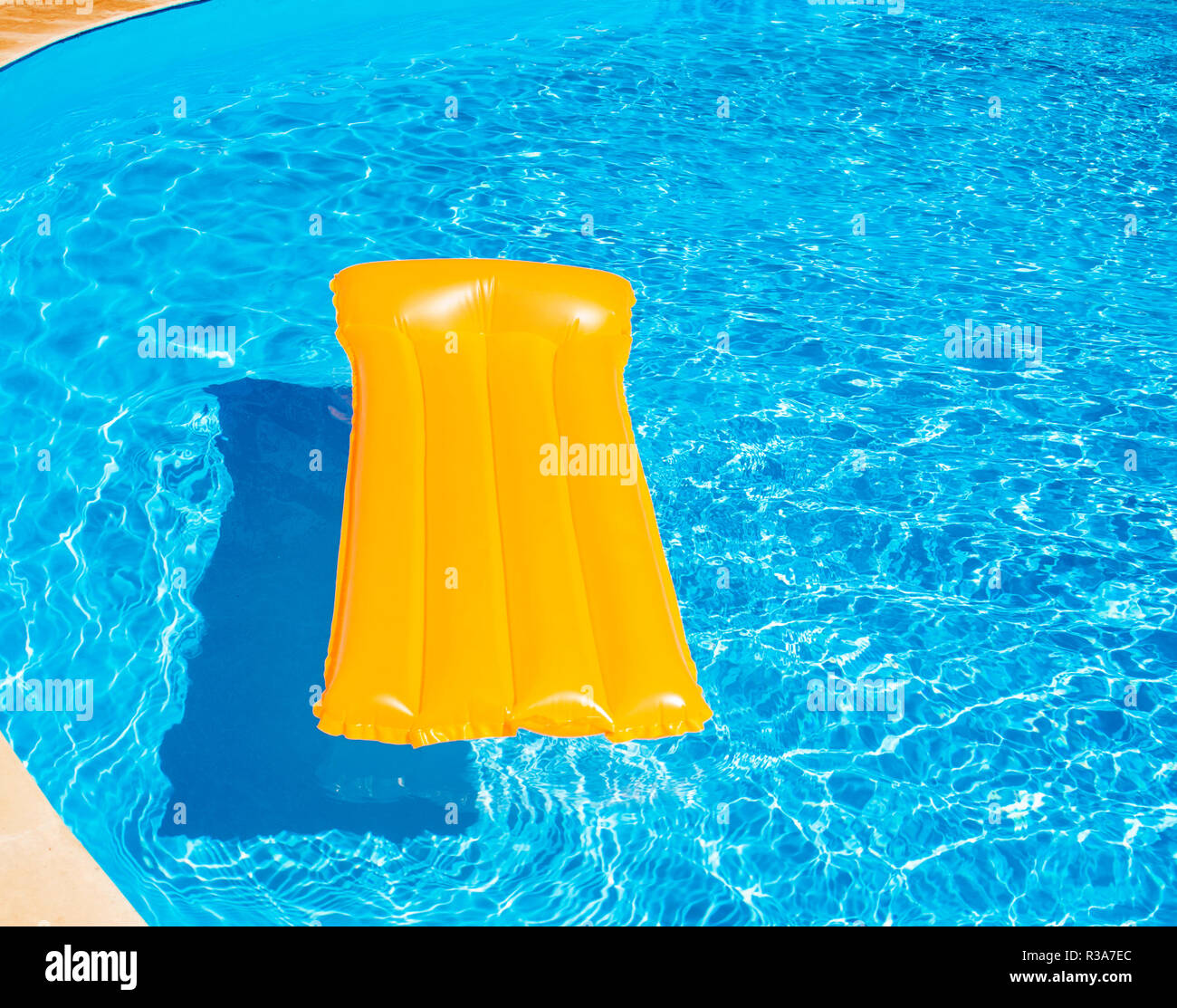 Orange inflatable mattress floating in the pool Stock Photo - Alamy