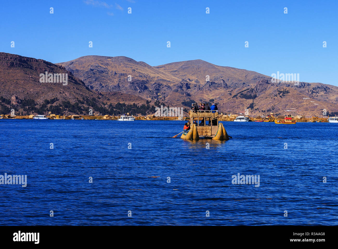 A traditional totora reed boat with tourists at Lake Titicaca, Puno ...