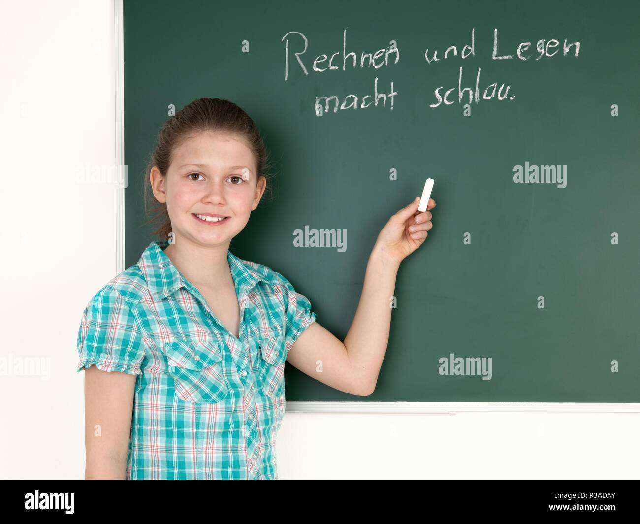 student standing in front of blackboard lessons Stock Photo - Alamy